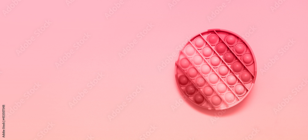 Colorful anti-stress fidget push pop it sensory toys on pink background ...