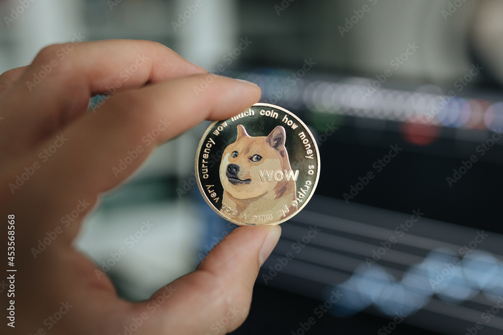 Dogecoin meme coin. Cryptocurrency closeup held between two fingers ...