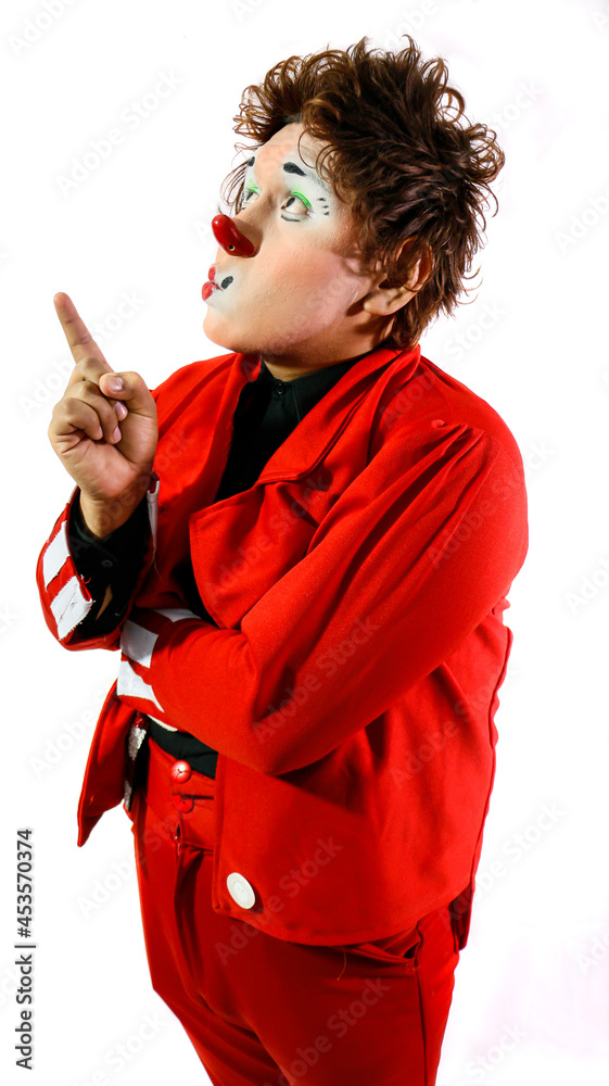 Gestures of a cute clown in front of the camera and with a white ...