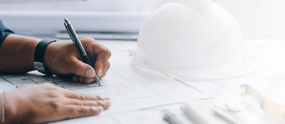 architect drawing on a blueprint on architectural project at the ...