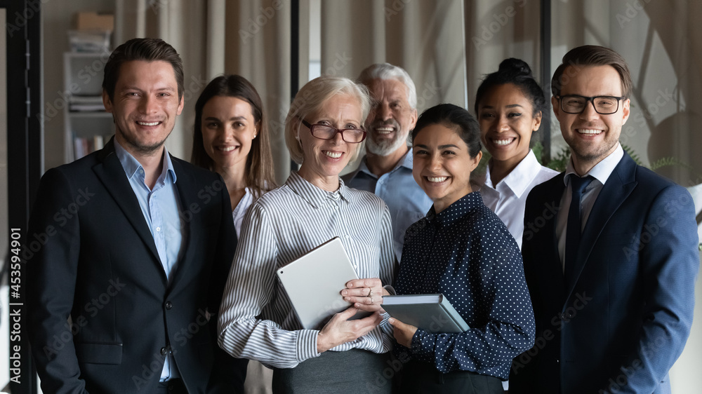 Portrait of smiling diverse employees workers with mature team leader ...
