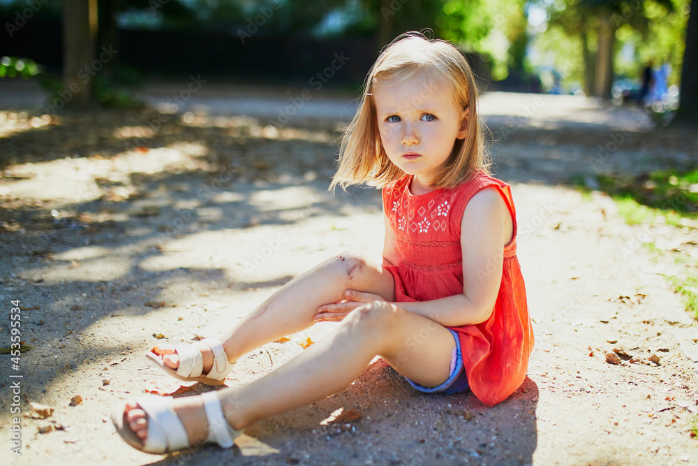 Cute little girl sitting on the ground after falling down Stock Photo ...