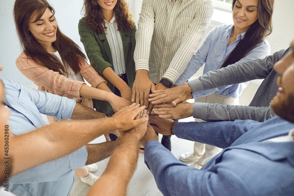 Fotografia do Stock: Team of happy male and female colleagues fold ...