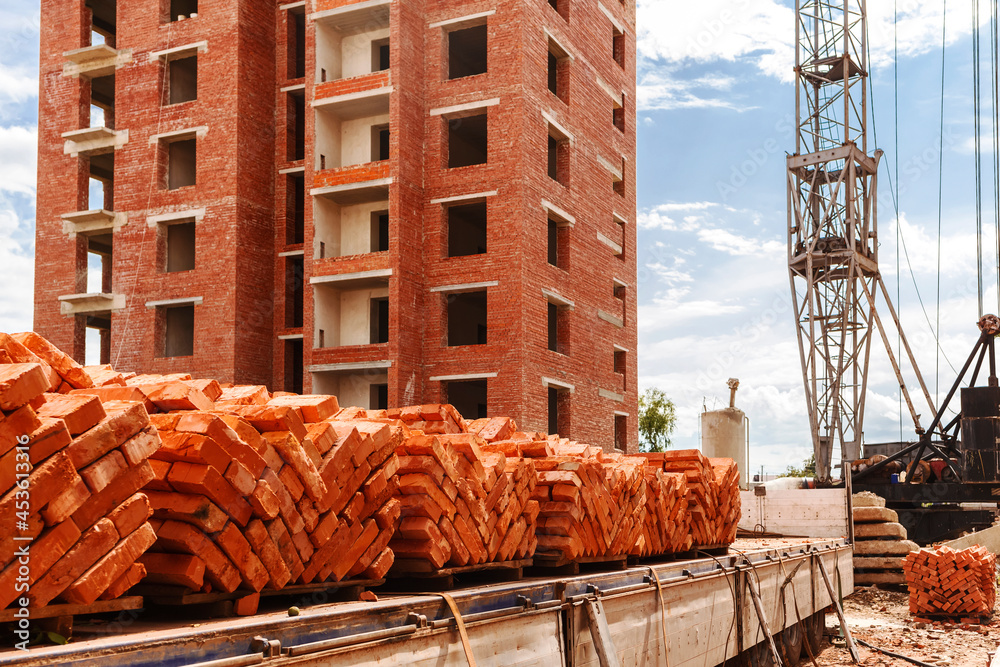 Pile of bricks on construction site. Stack of bricks on brick high rise ...