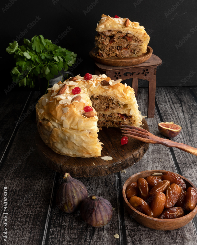 Moroccan pastila pie (bastela) on a wooden background. Chicken Bastille ...