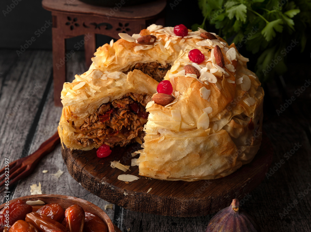 Moroccan pastila pie (bastela) on a wooden background. Chicken Bastille ...
