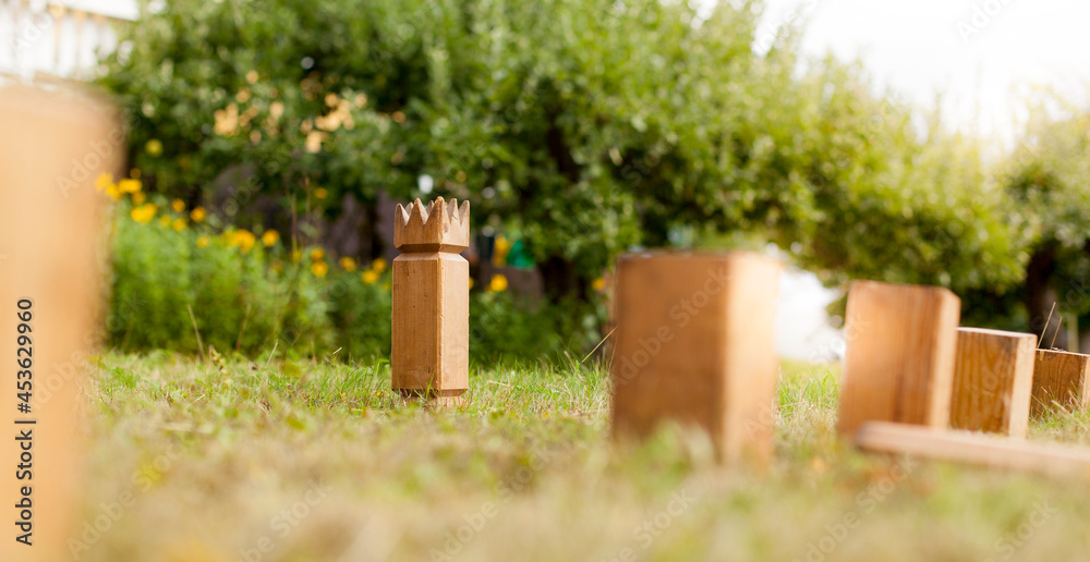 Wikingerschach (Kubb) aus Holz in Garten aufgestellt. Wooden Kubb sticks in garden. Wooden Kubb ...