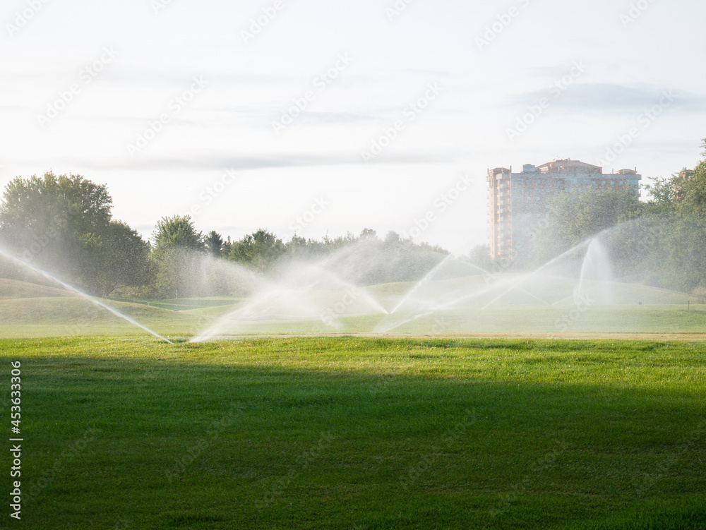 Irrigation system watering a golf course Stock Photo | Adobe Stock
