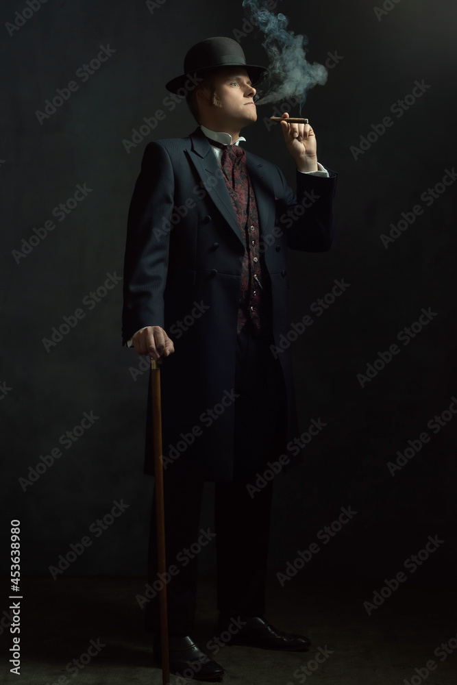 Cigar smoking young man in stylish vintage Victorian clothes with a ...
