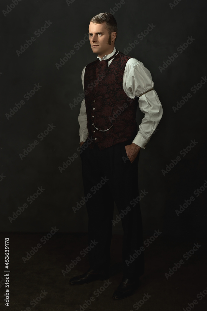 Shadowy portrait of a young man in vintage Victorian attire in a room ...