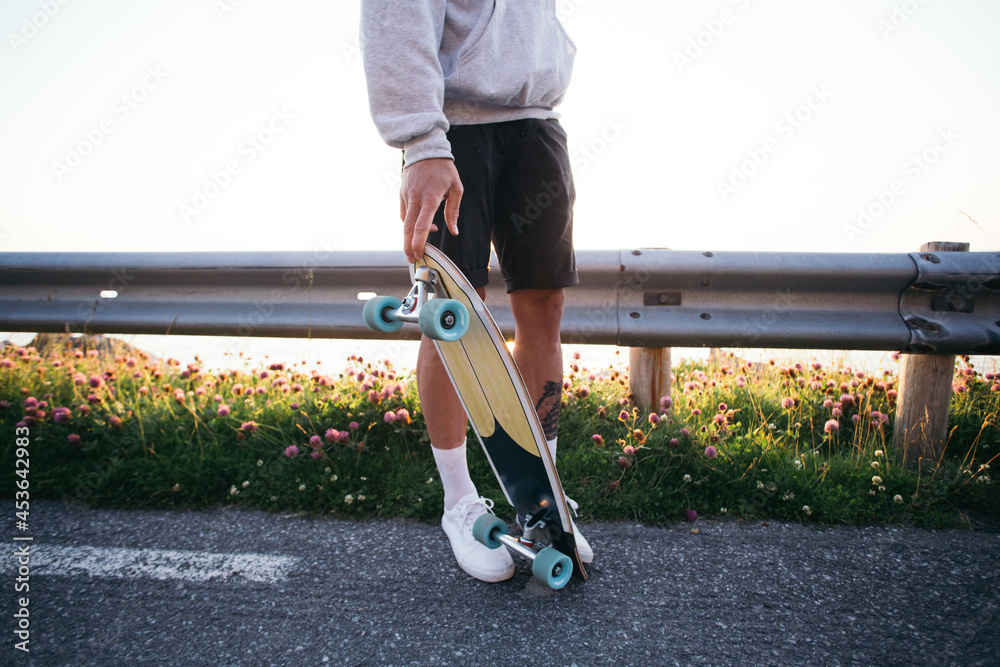 Cool trendy young unrecognizable man stand on sunny street and hold ...