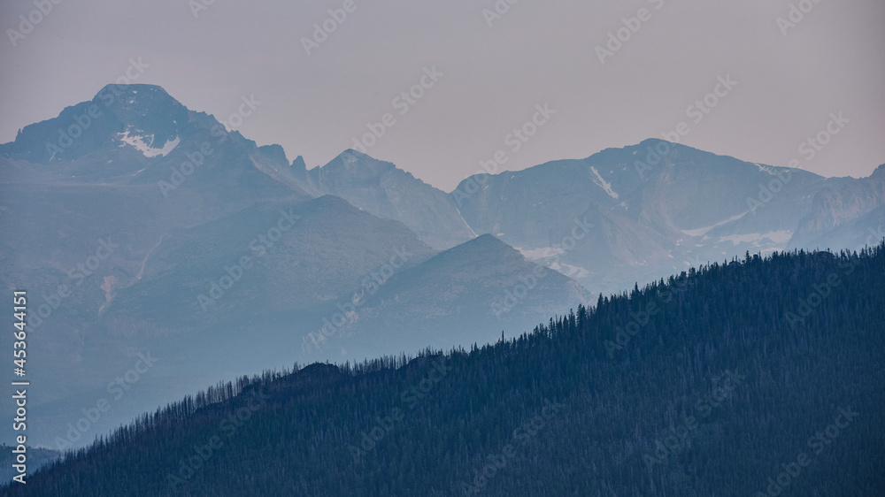 Rocky Mountains and forest trees shrouded in haze and smoke due to ...
