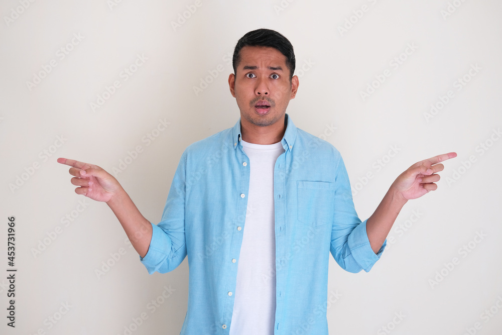 Adult Asian man pointing his fingers to the left and right with ...