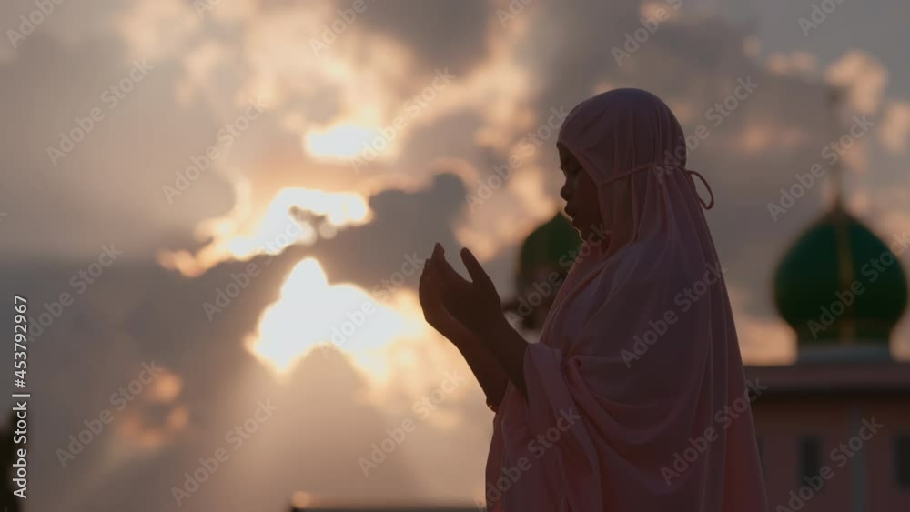 Muslim girl praying during sunset with mosque background, Panorama ...