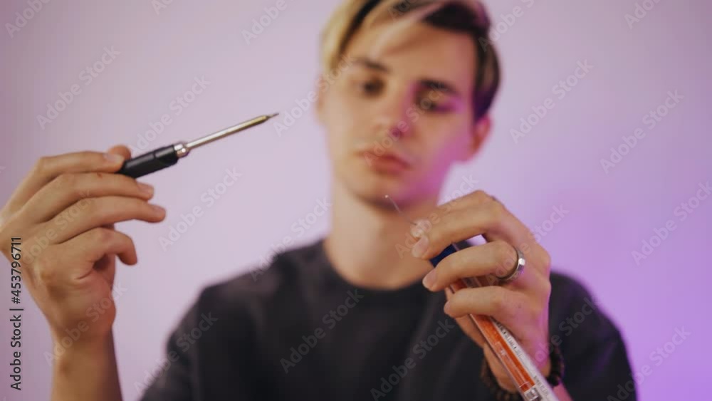 The guy takes a hot soldering iron and puts tin on it. Shooting of the ...