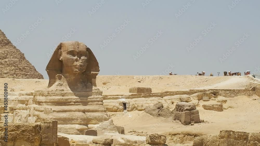 View of the Sphinx at the pyramids of Giza and horse carts for tourists ...