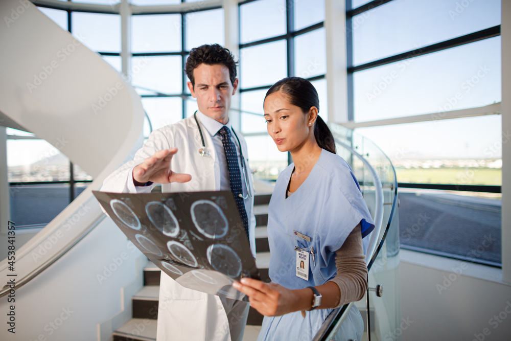 Doctor and nurse viewing head x-rays on hospital staircase Stock Photo ...