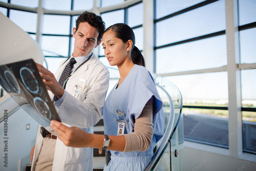Doctor and nurse viewing head x-rays on hospital staircase Stock Photo ...