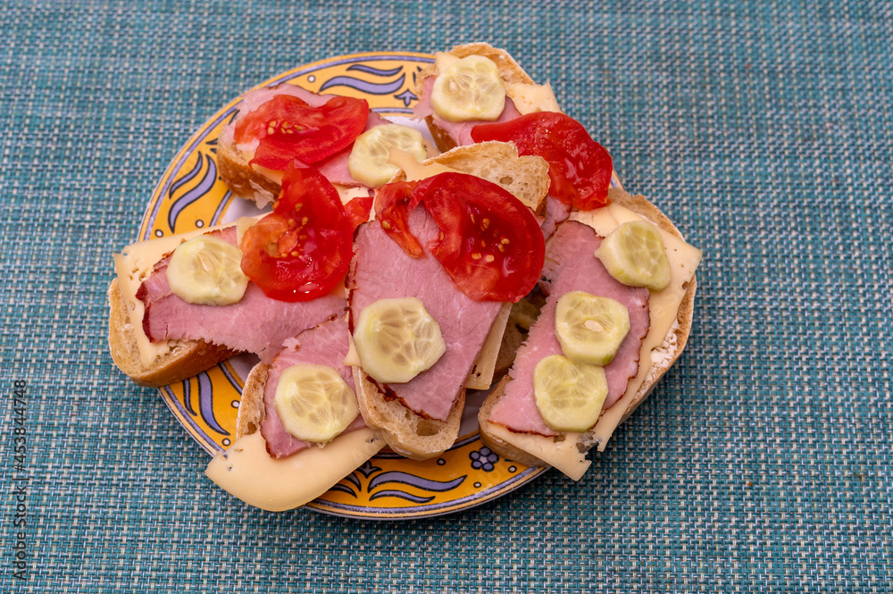 kanapki z wędliną, warzywami, pomidorem, serem, ogórkiem na talerzu ...