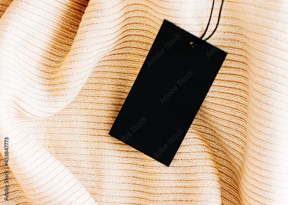 Beautiful warm fabric and black price tag as luxury shopping background ...
