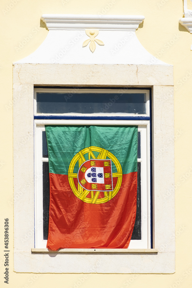 beautiful flag of portugal hanging on a window of a house in Lagos ...