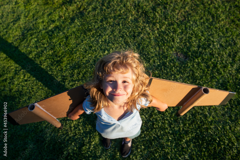 Funny child boy flying in plane made craft of cardboard wings. Dream ...