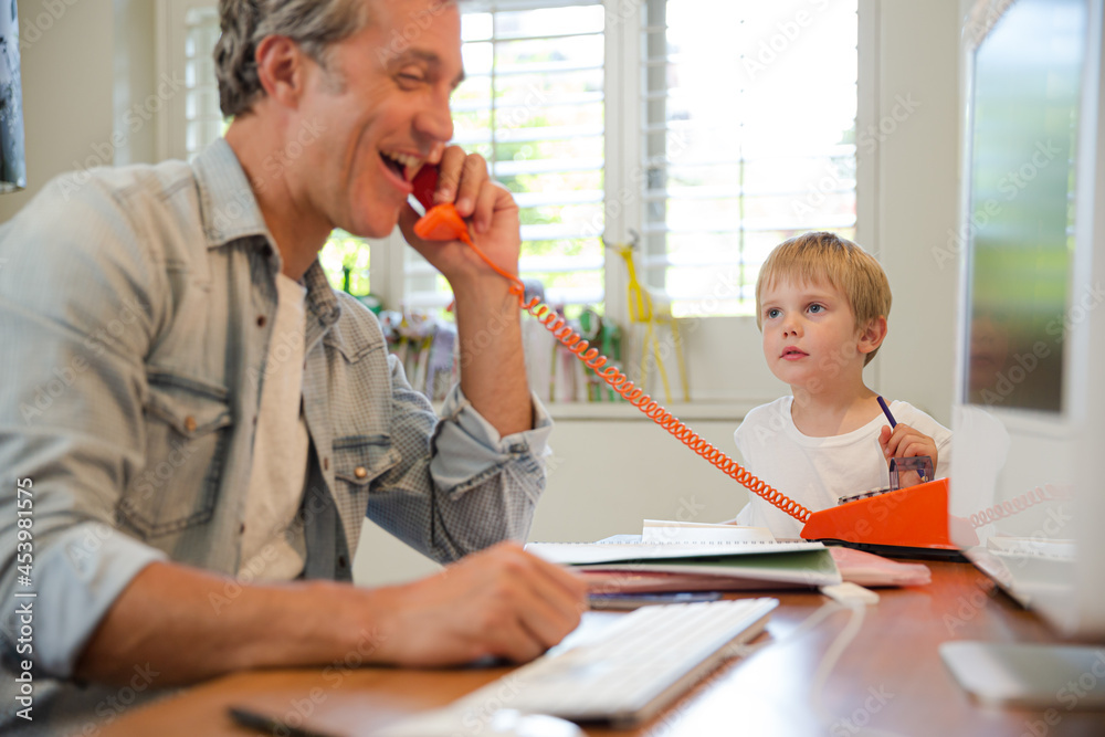 Father and son using phone in home office Stock Photo | Adobe Stock