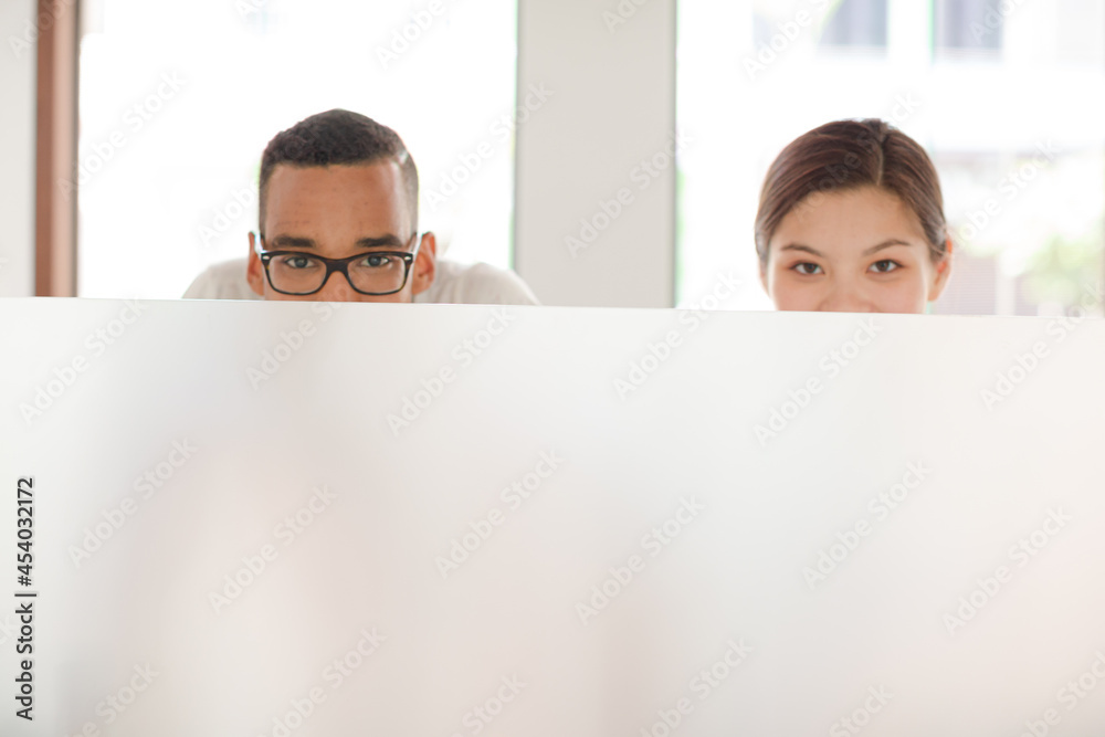 People peeking over cubicle in office Stock Photo | Adobe Stock