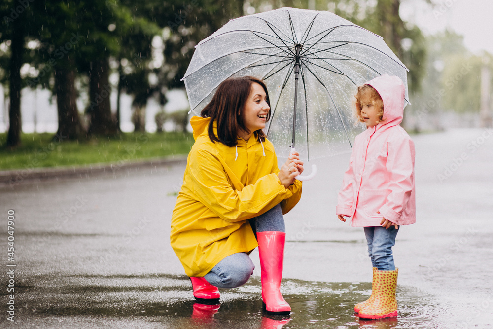 Mother with daughter walking in the rain under the umbrella Stock Photo ...