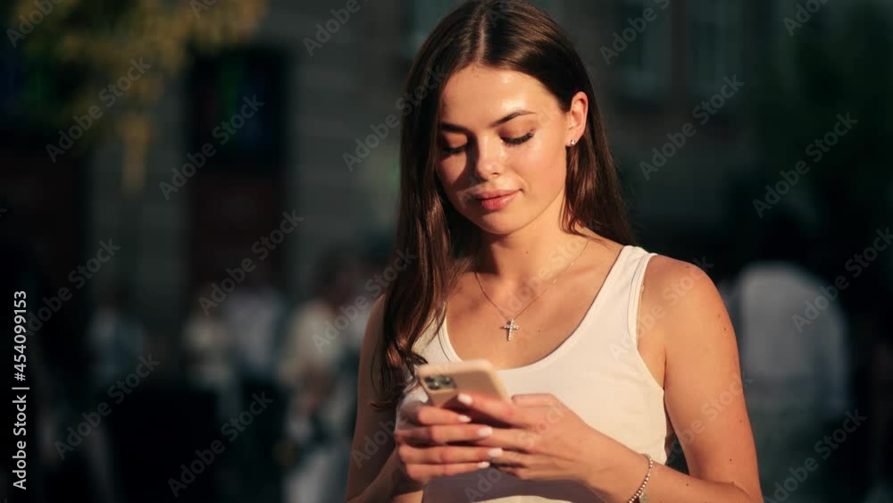 Beautiful young woman is using an app in her smartphone device to send ...