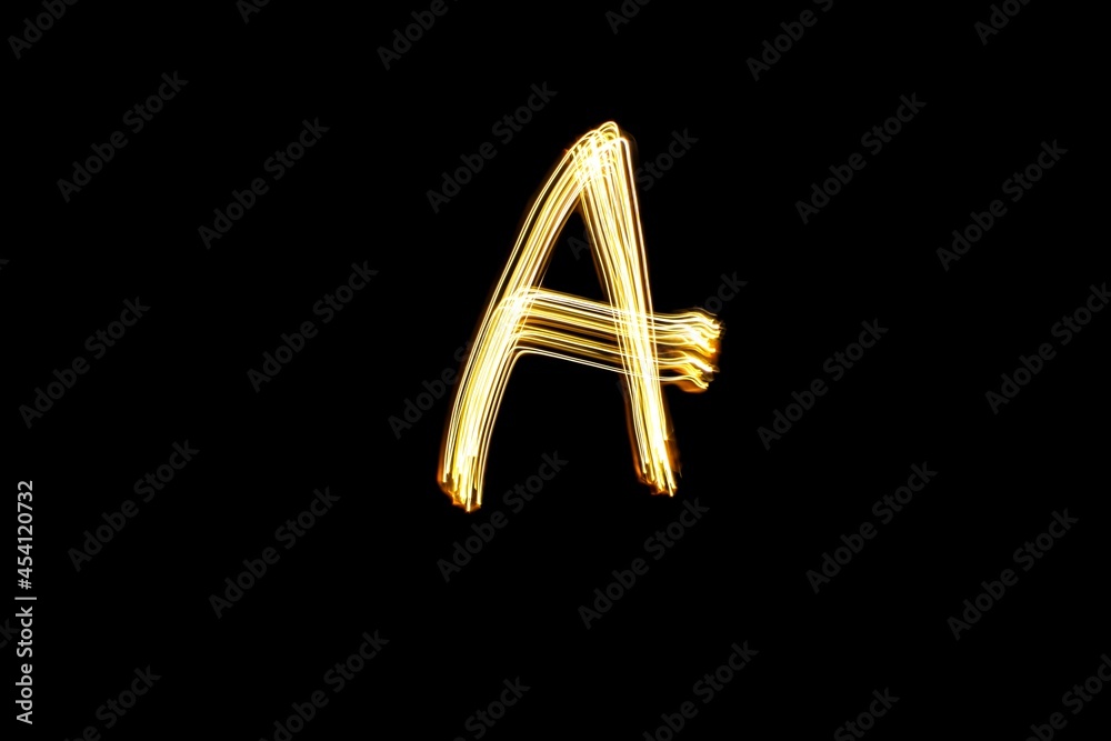 Drawn letter A with gold lights against black background. Light ...