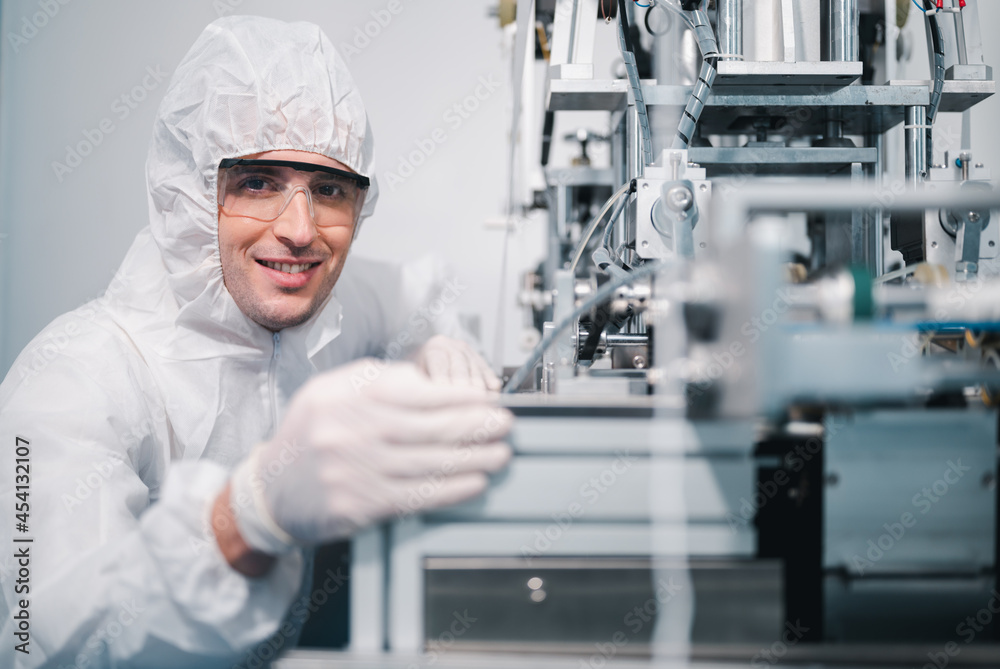 Scientists wearing protective clothing Inspect mask making machines in ...