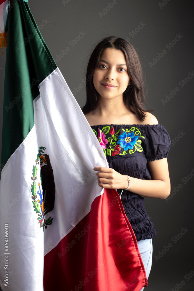 Beautiful Young hispanic woman with flag of Mexico wearing the typical ...
