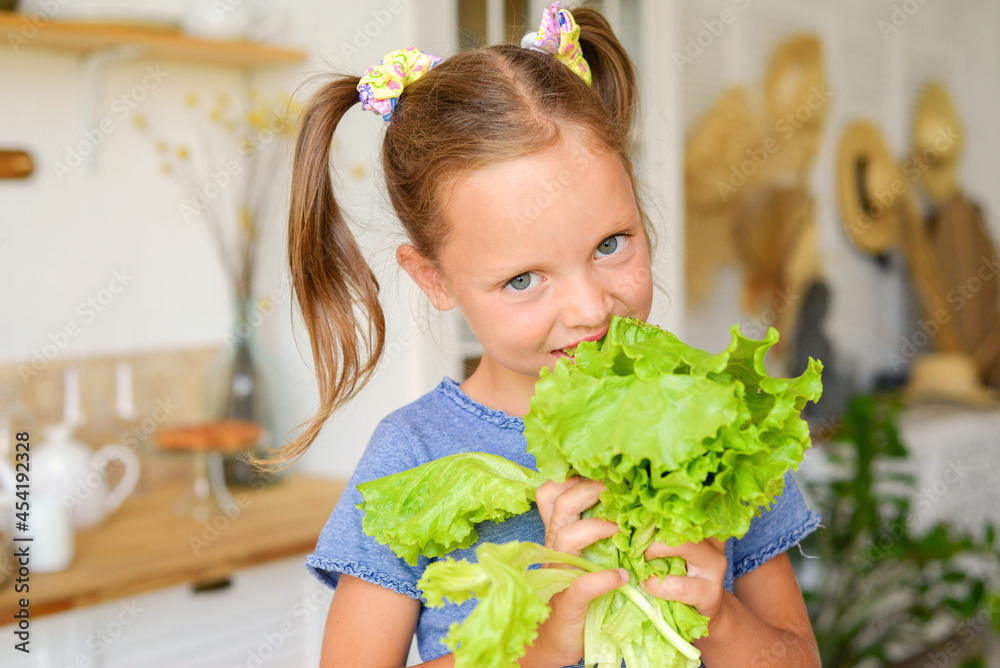 Adorable child is cooking in the kitchen. Pretty pretty girl prepares ...