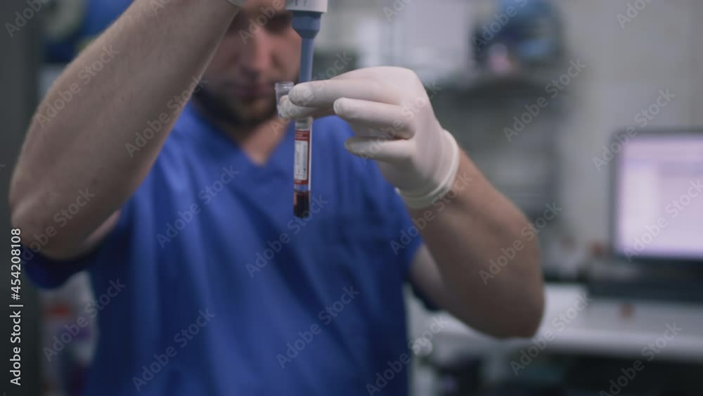 A man doctor scientist makes a blood test in a test tube. Scientific ...