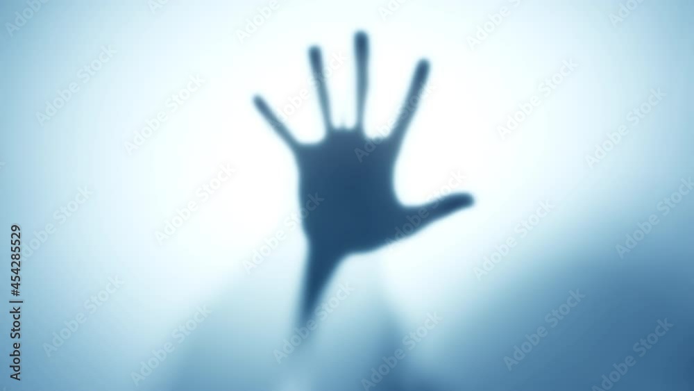 4k video of a silhouette of a man's hands behind a translucent glass ...