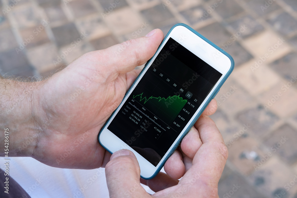 Stock market investor hands holding a phone investment app index growth ...