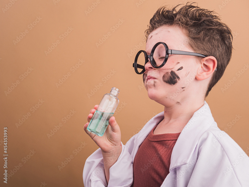 Crazy scientist boy with dirty face smelling substance from bottle foto ...