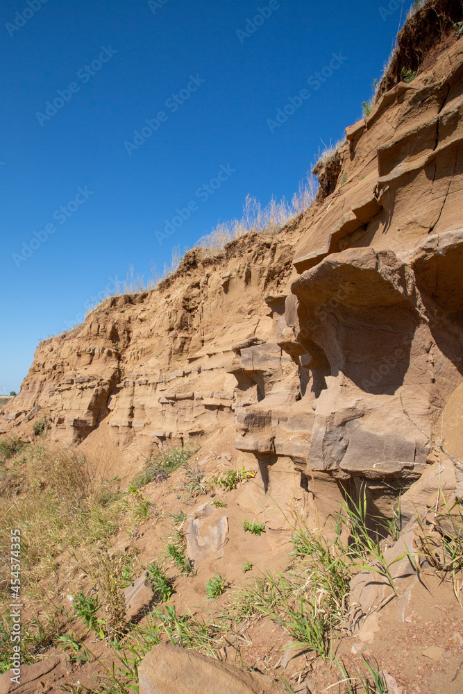 steep ravine slope, sandstone polished by wind and water erosion, stone ...