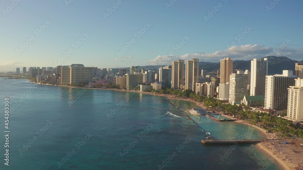 Panning aerial drone slowly flying over a colorful Honolulu Skyline ...