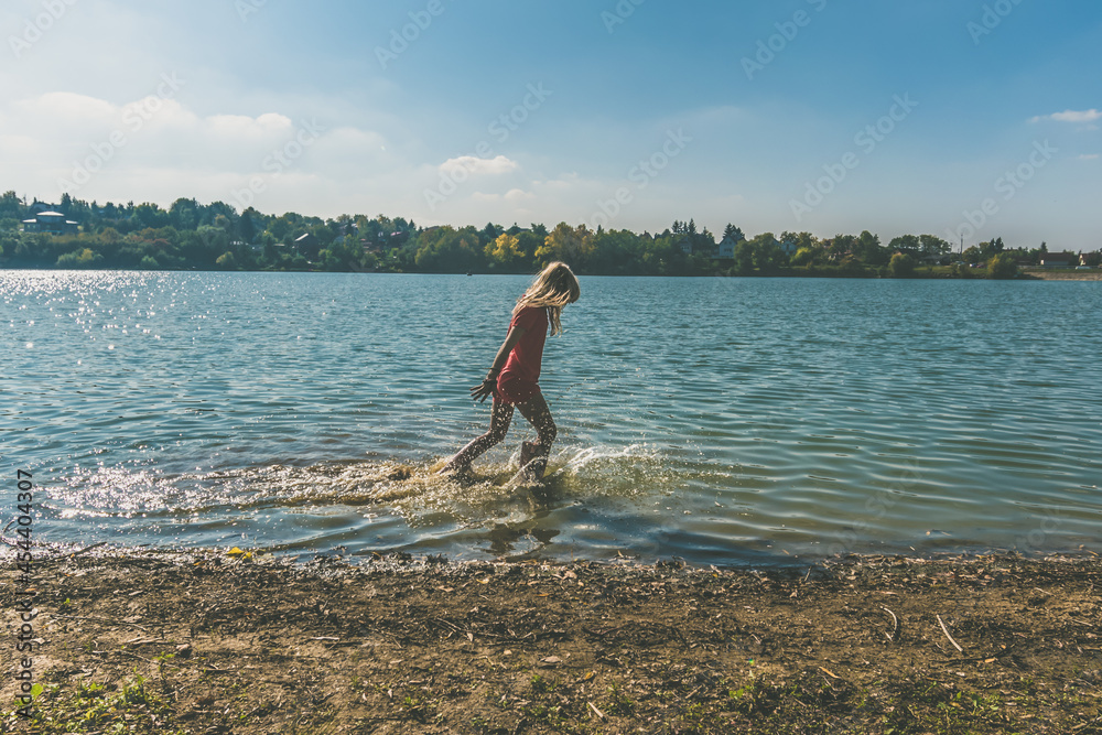 one child splashing water while running in the water Stock Photo ...
