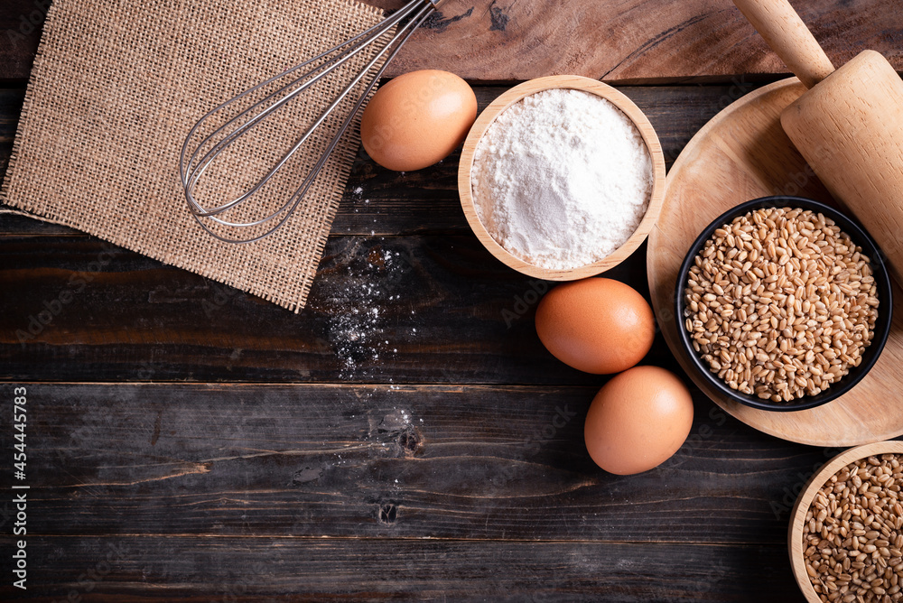 Wheat grain, flour, egg and kitchen utensil for bakery cooking on ...
