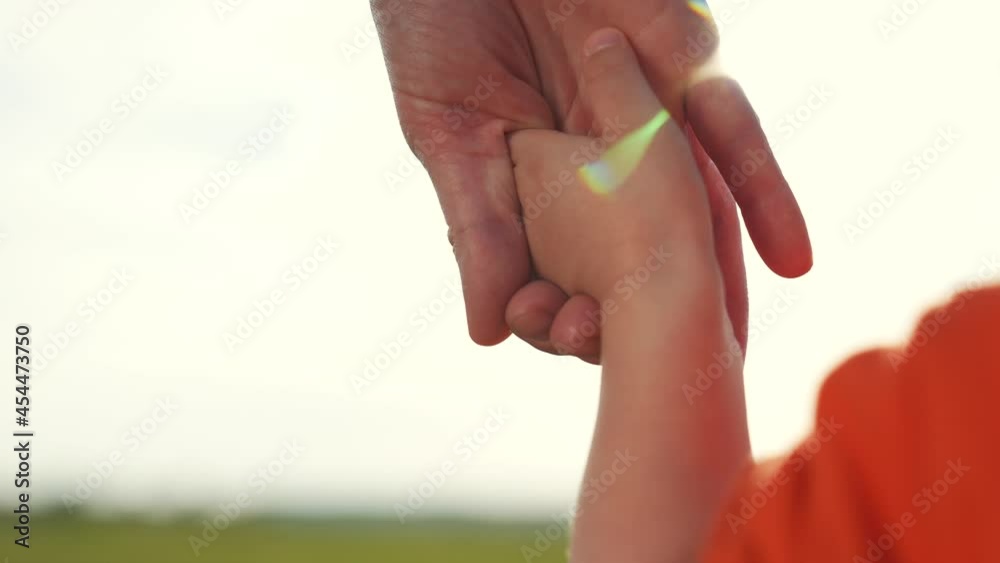 Helping hand. Mom holds baby by hand. Family teamwork. Happy kid holds ...
