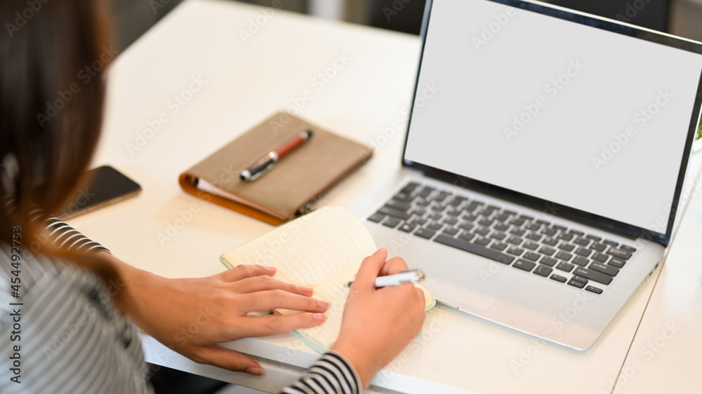 Young businesswoman taking notes in laptop computer, laptop blank ...
