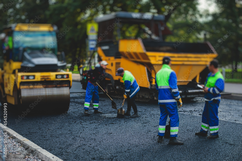 Process of asphalting, blacktopping and paving, group of workers with ...