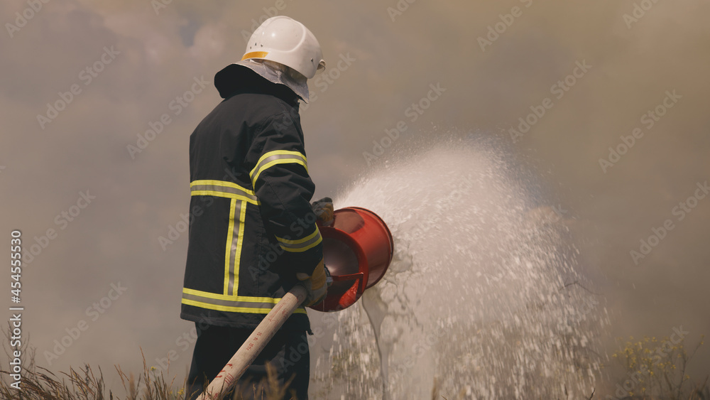 Fireman extinguishing fire in nature Stock Photo | Adobe Stock