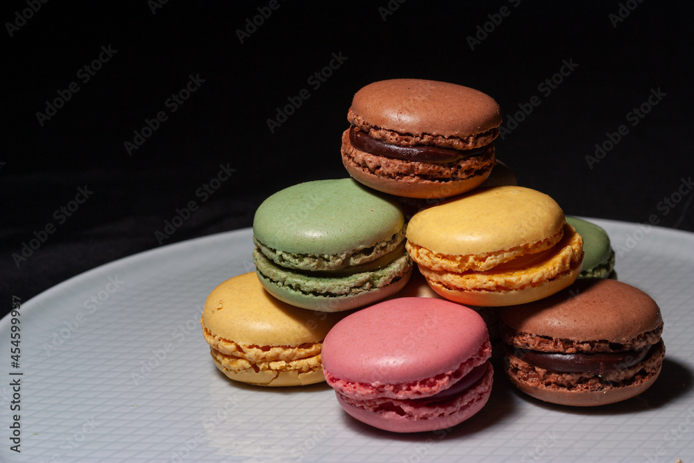 Macarons de colores sobre fondo negro. Concepto gastronomía repostería ...