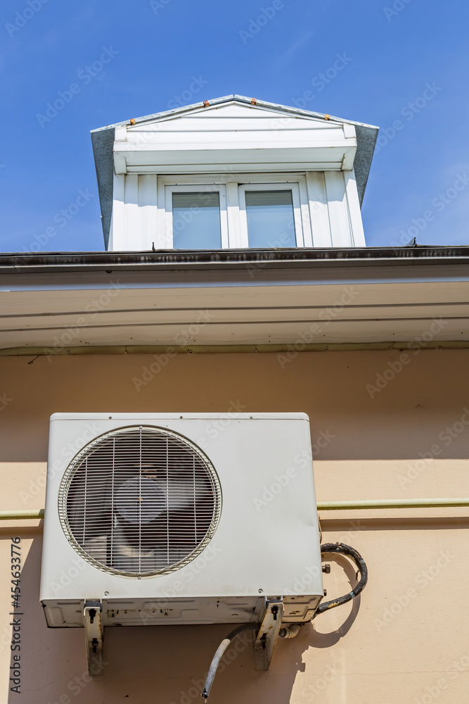 External box of an old air conditioner with a fan on the stone wall of ...