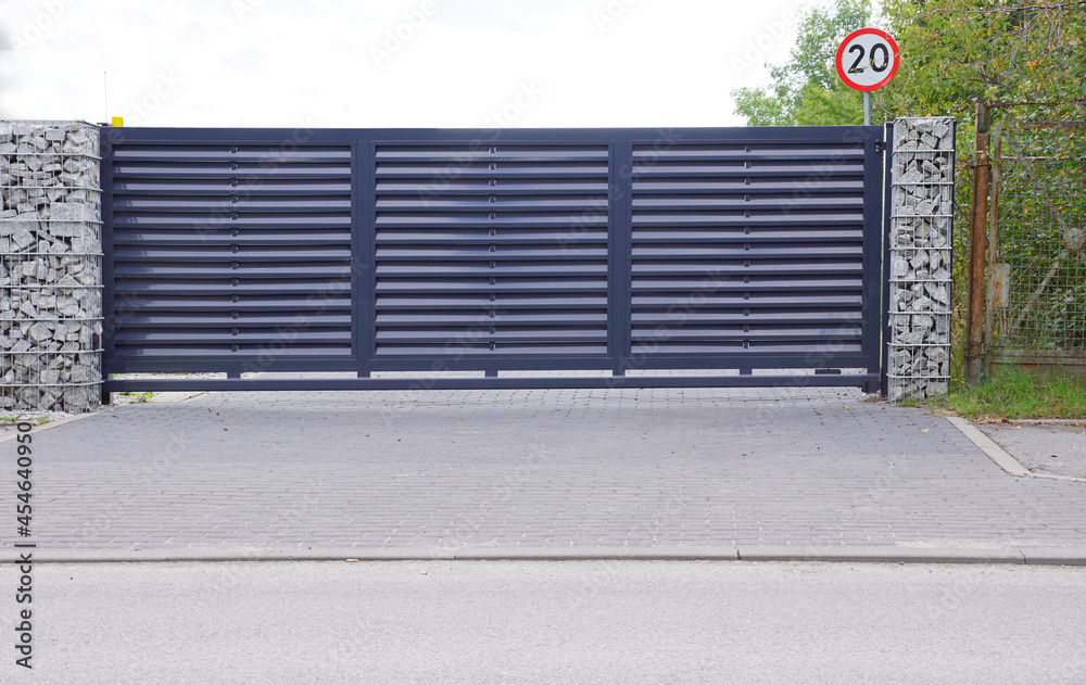 Gabion. Automatic entrance gate used in combination with a wall made of ...