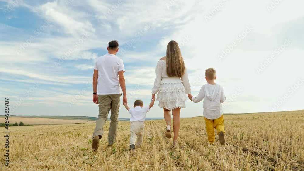 Farmer family with children sons walks joining hands among field on ...